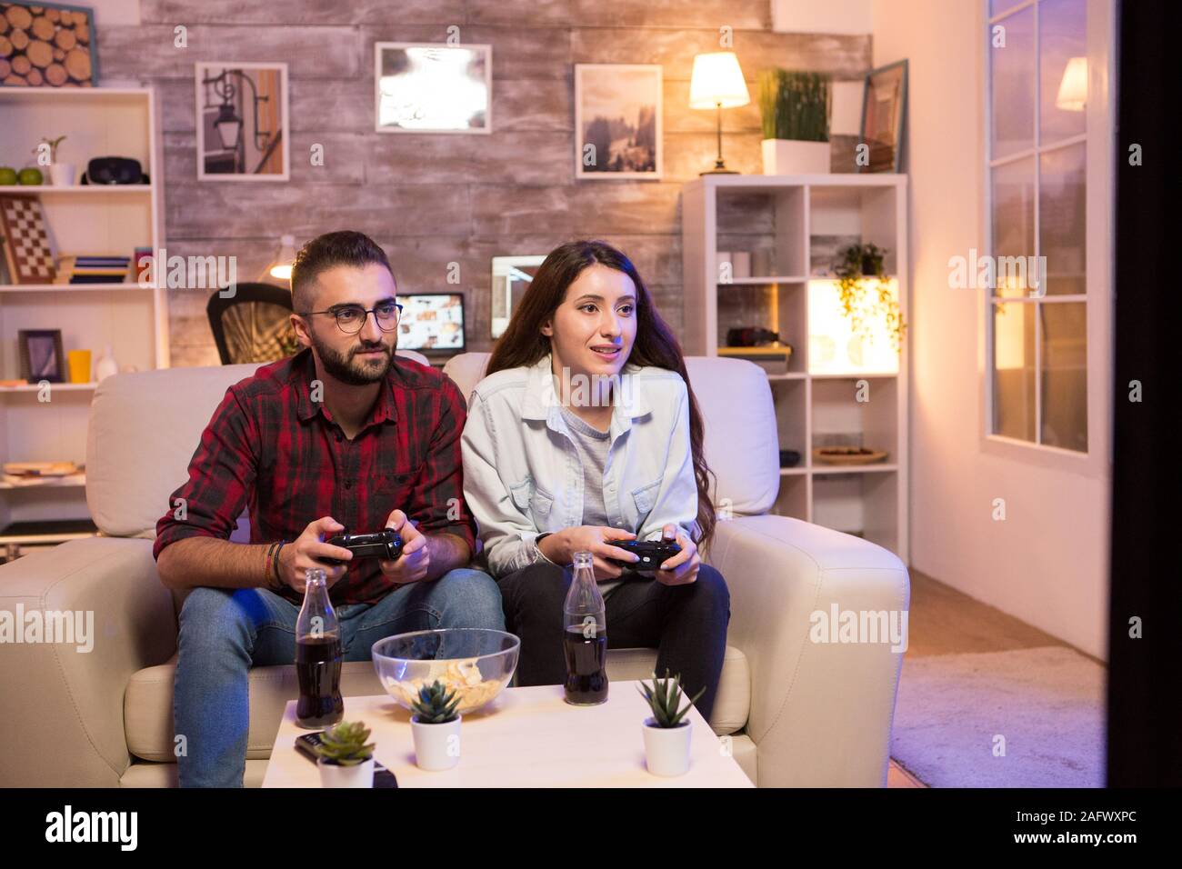 Boyfriend playing video games with his girlfriend on television using ...