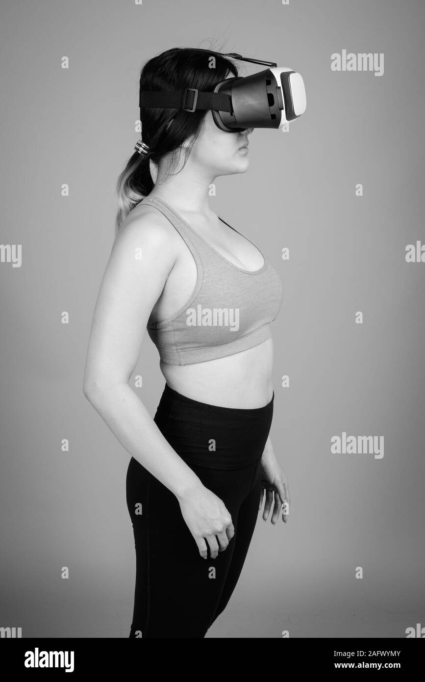 Young Beautiful Asian Woman Ready For Gym Against Gray Background Stock