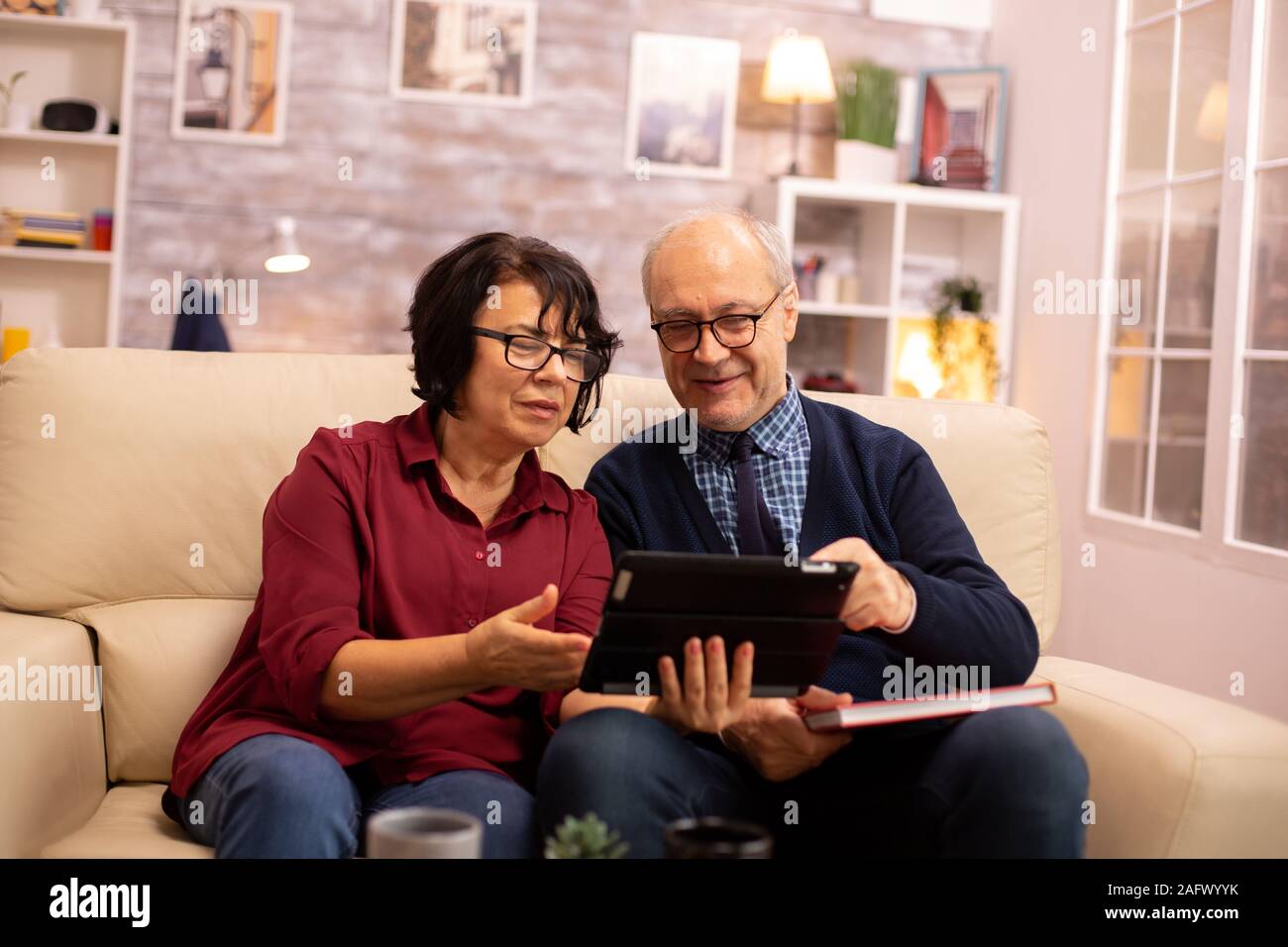 Beautiful old couple using a digital tablet to chat with their family ...