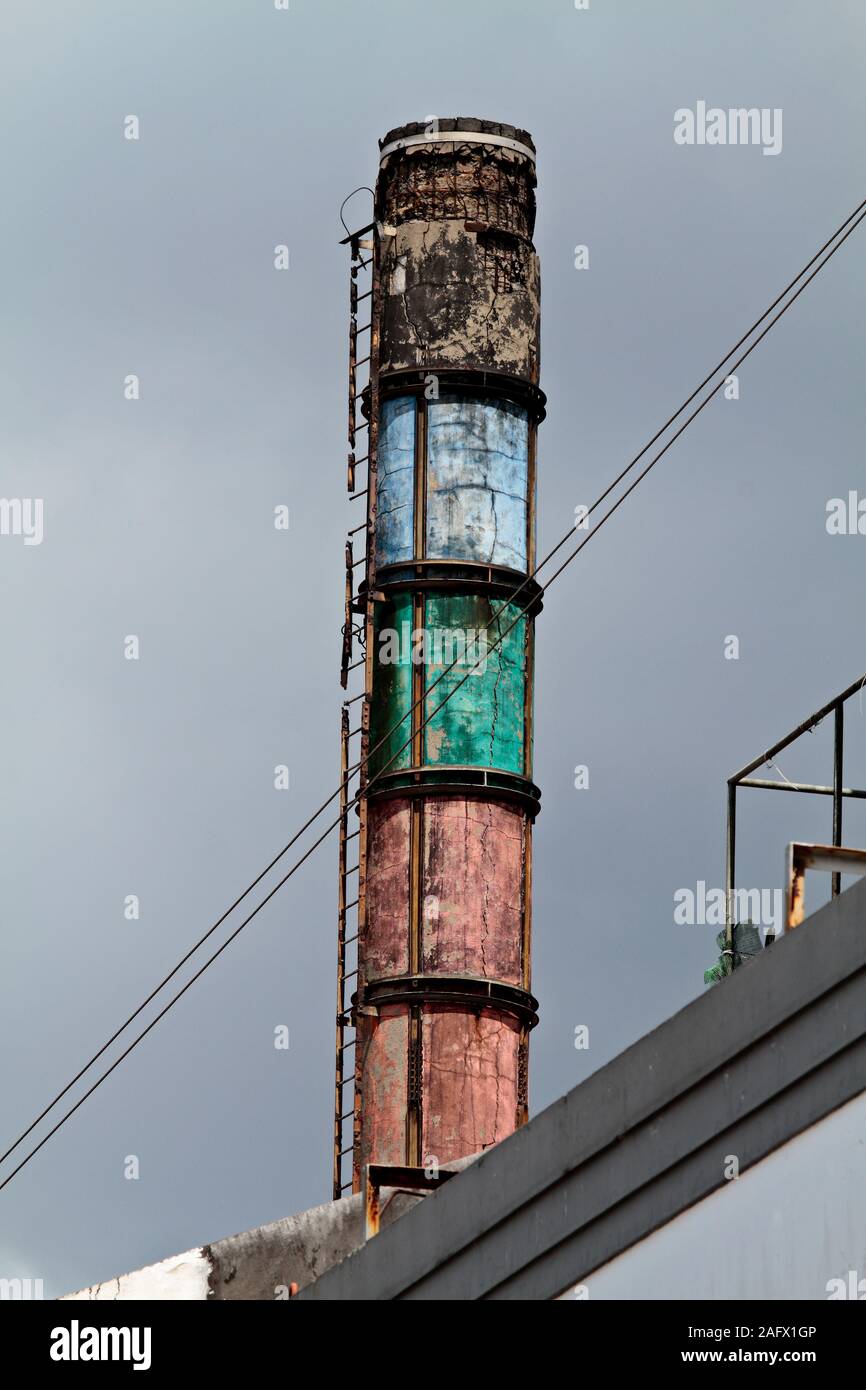 An old dirty and rusty pipe out of use against the cloudy grey sky ...