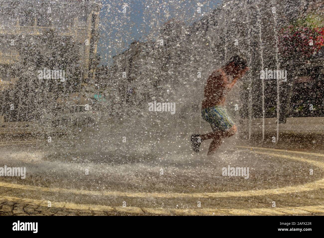 Person running through water fountains in a park Stock Photo - Alamy