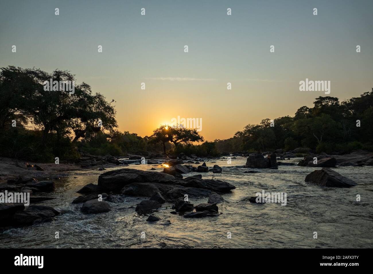 Sunset in Malawi river with trees, rocks and text space Stock Photo - Alamy