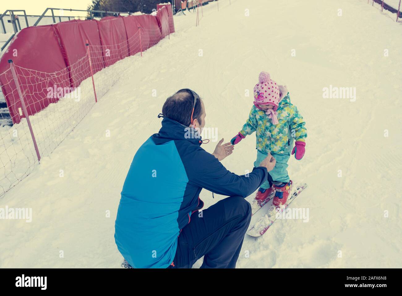 Active father teaching her daughter to ski Stock Photo - Alamy