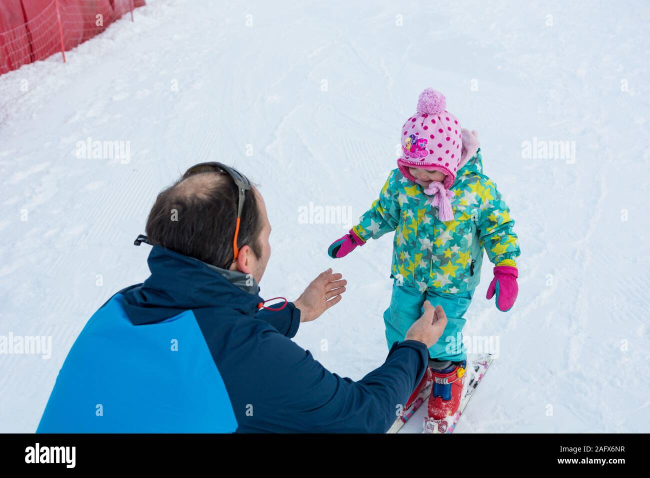 Active father teaching her daughter to ski Stock Photo - Alamy