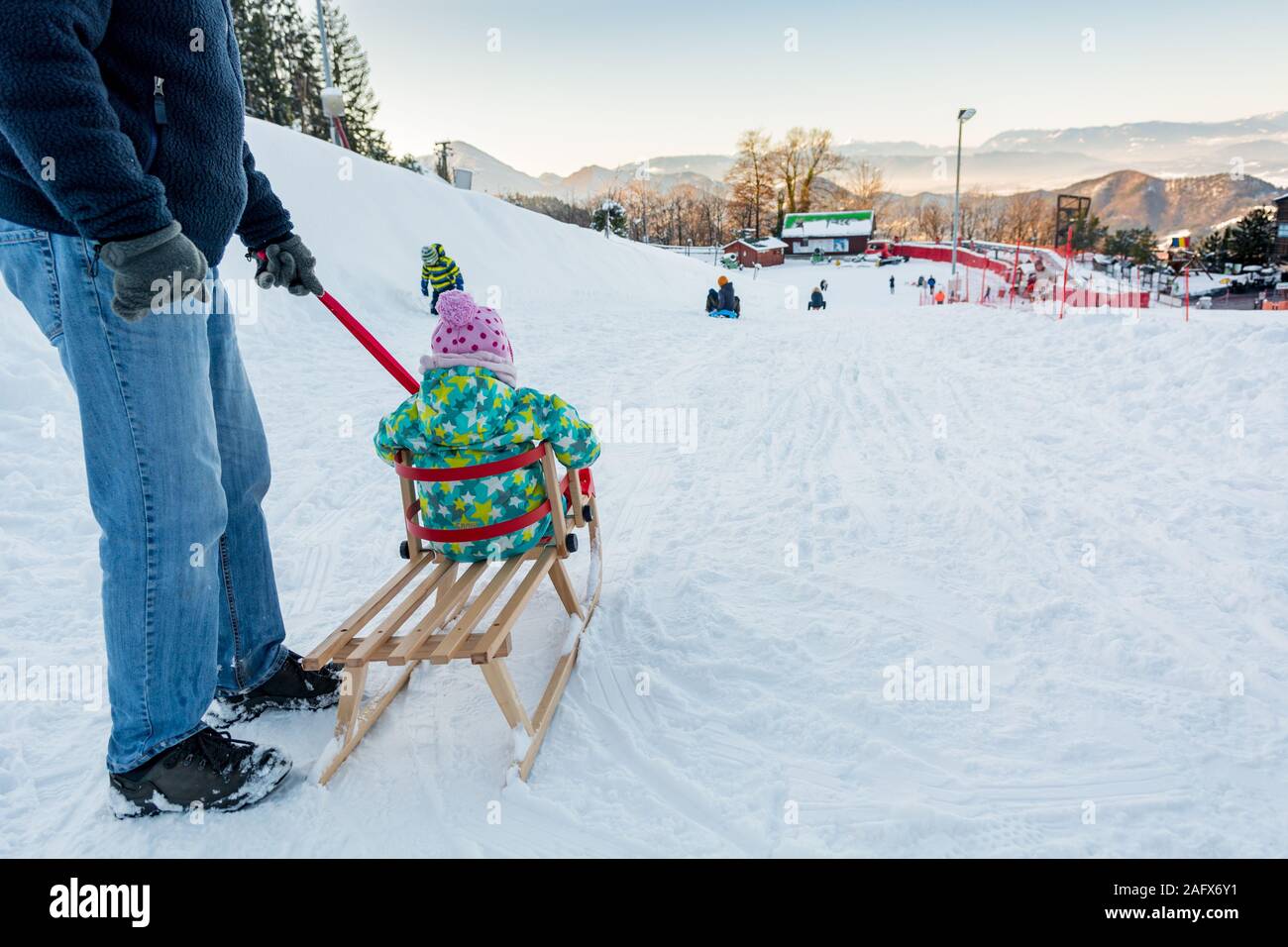Father and daughter getting ready to enjoy the snowy slope with wooden ...
