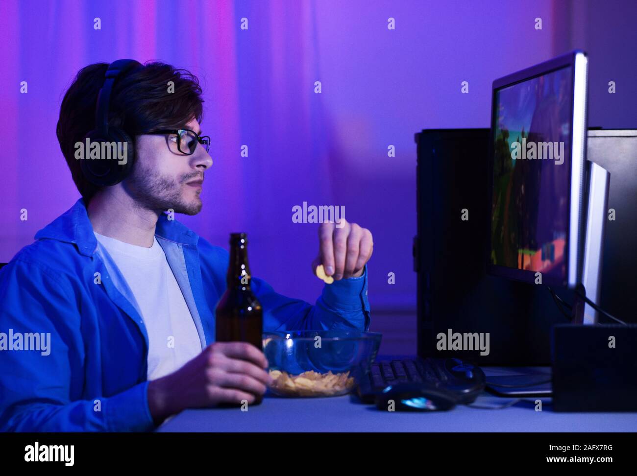 Gamer having break and drinking beer with chips Stock Photo - Alamy