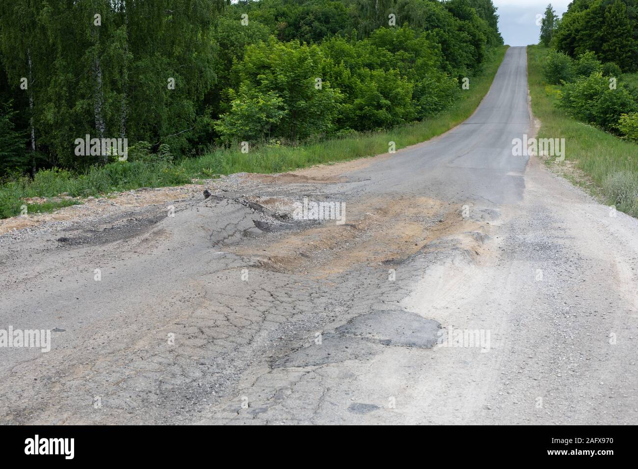 Damaged road - cracked roadway. Track with broken asphalt Stock Photo ...