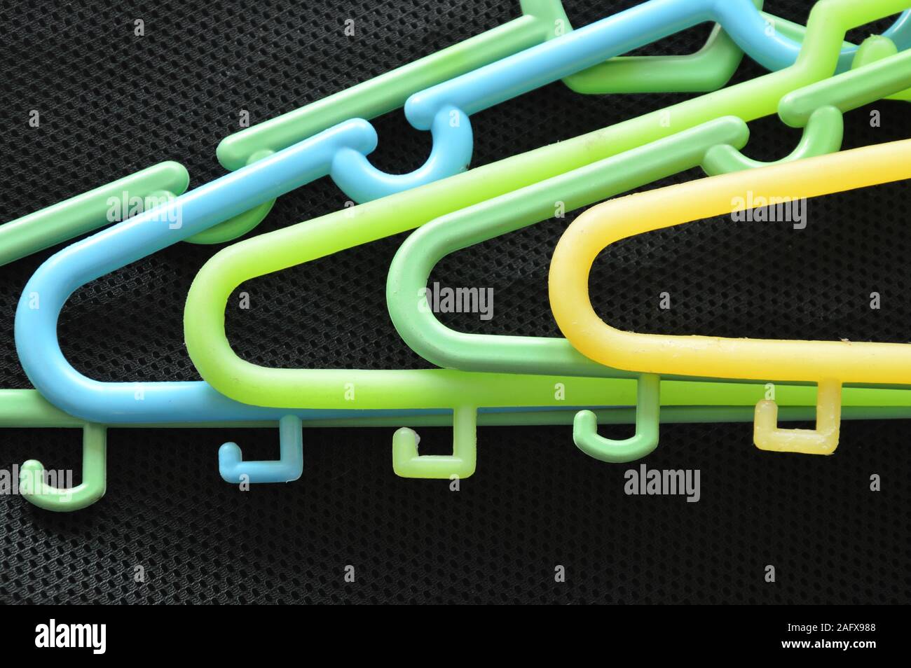 colorful plastic clothes hunger overlay on black fabric Stock Photo - Alamy