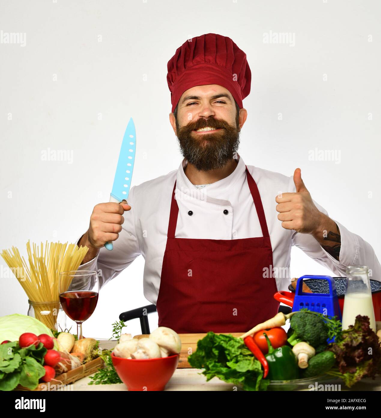 Restaurant cuisine concept. Cook with smile in uniform sits by kitchen ...
