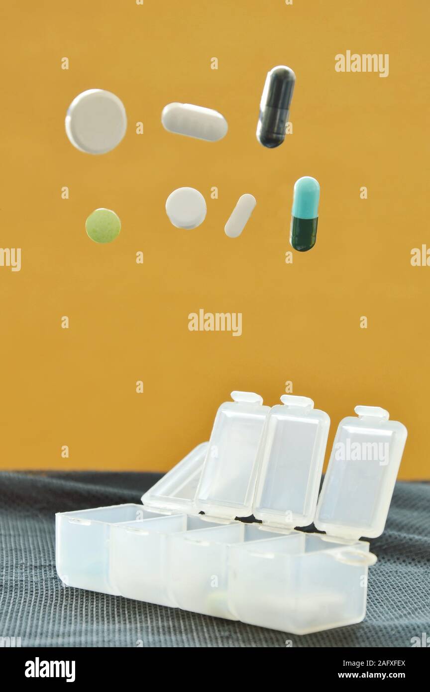 pill and capsule dropping to plastic box Stock Photo - Alamy