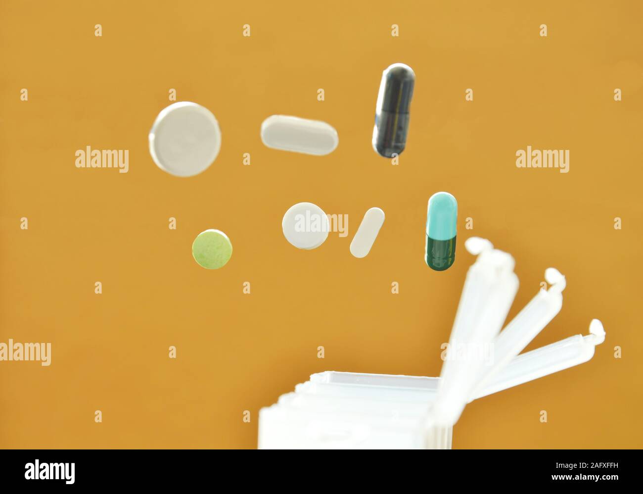 pill and capsule dropping to plastic box Stock Photo - Alamy