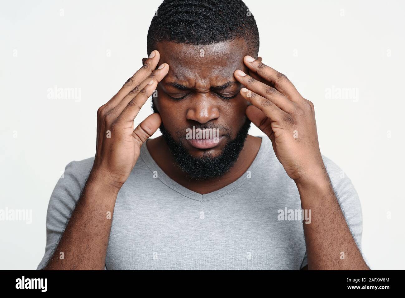 Black guy having headache, touching his temples Stock Photo - Alamy