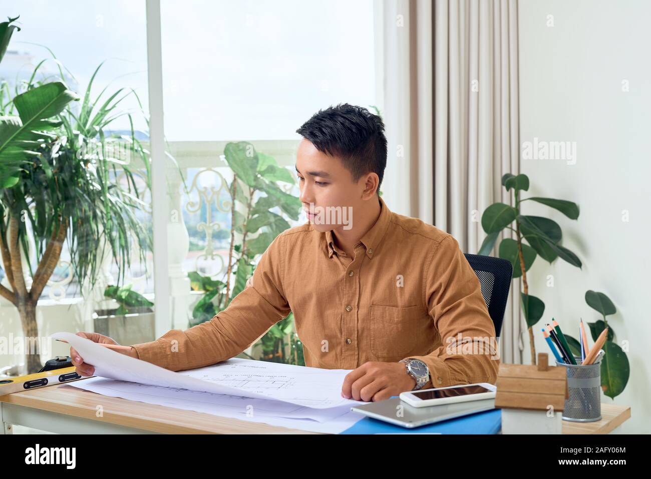 Asian architect man working on blueprint at his office Stock Photo - Alamy