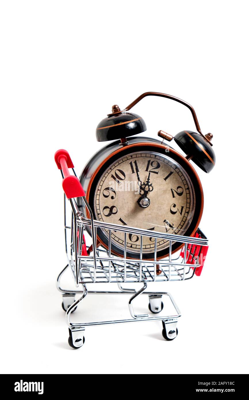 Retro alarm clock in shopping cart on white background Stock Photo - Alamy