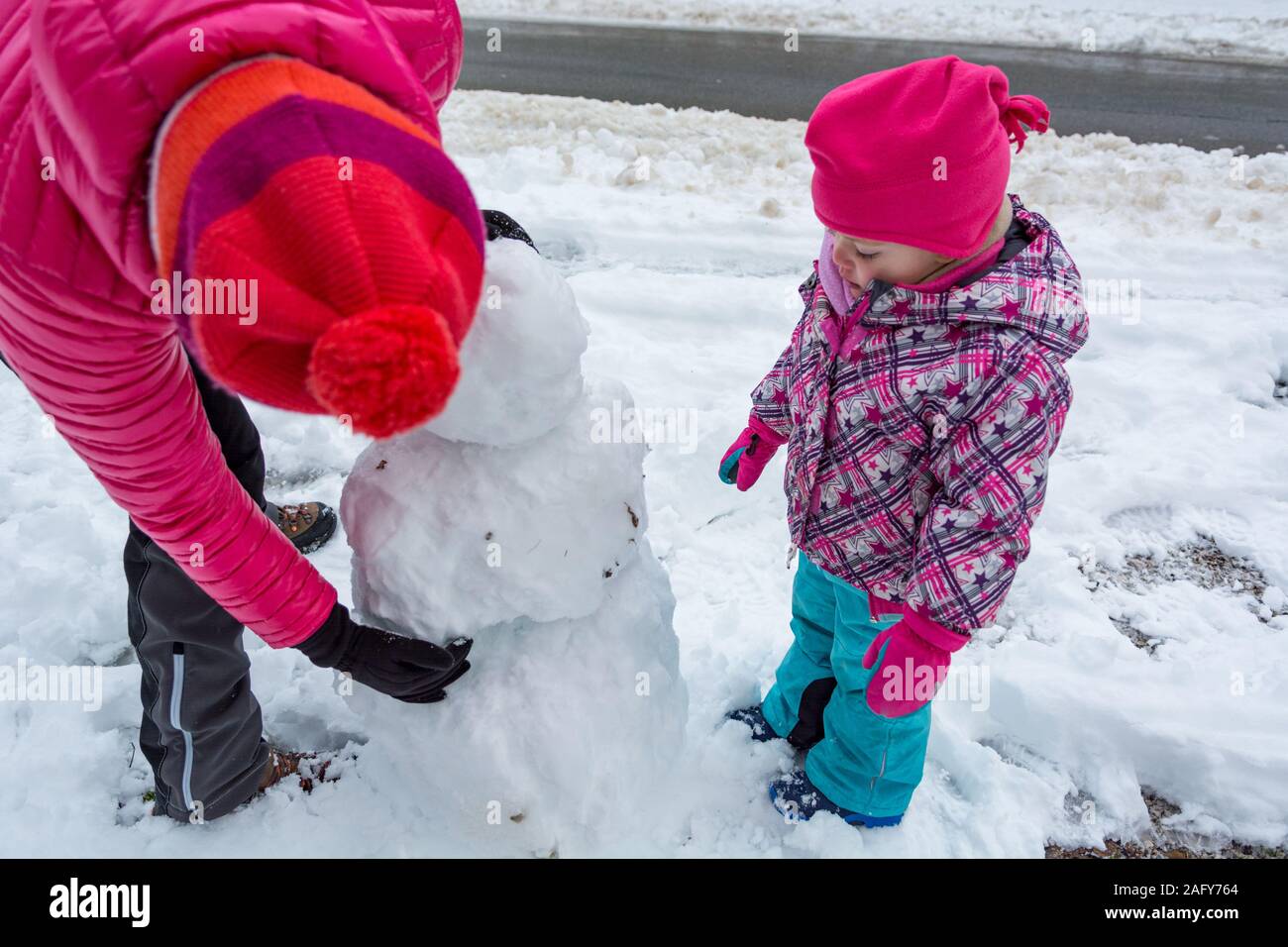 Mother and daughter building a snow outside enjoying the winter Stock ...