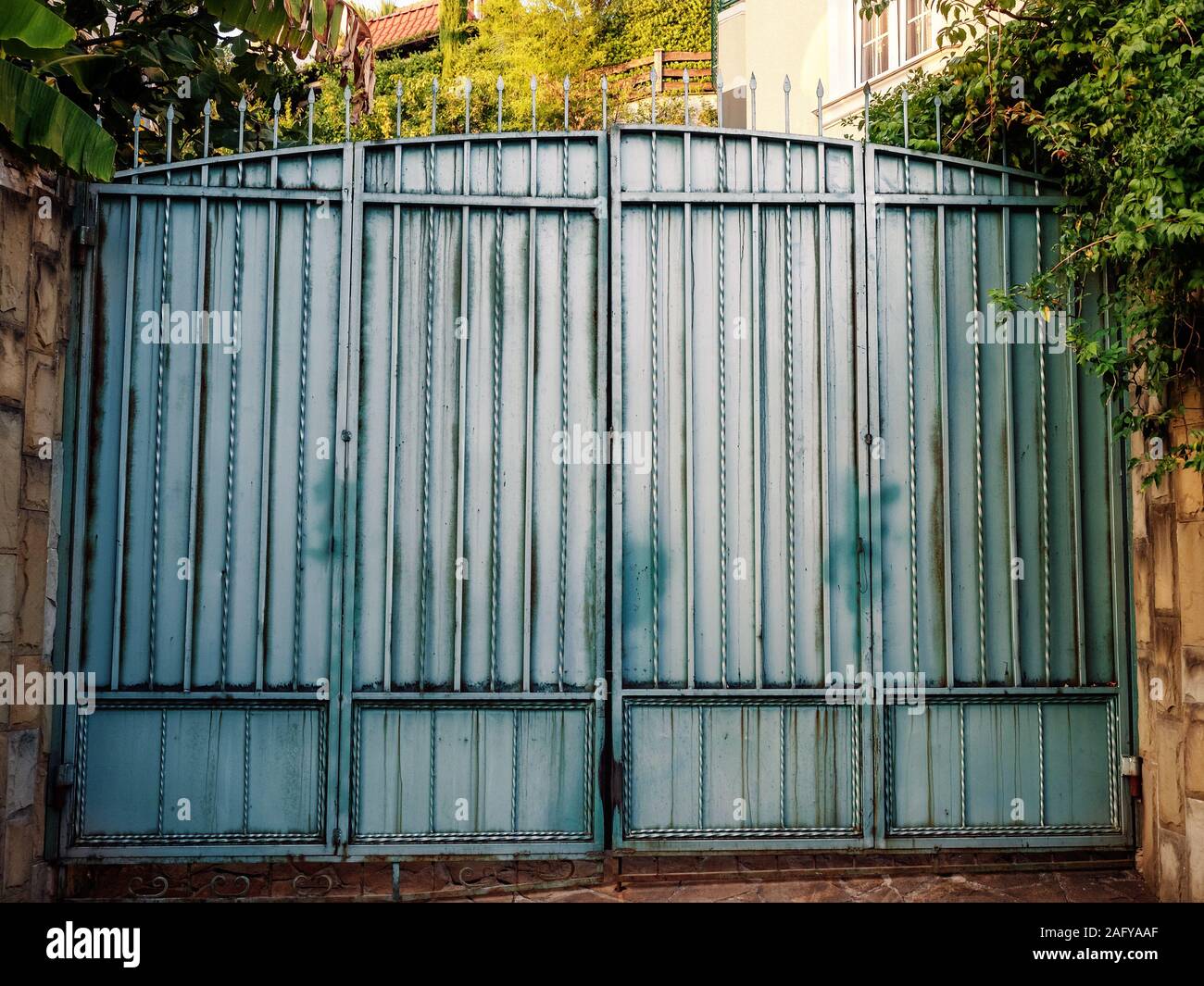 Large blue gates with wrought iron elements front view Stock Photo - Alamy