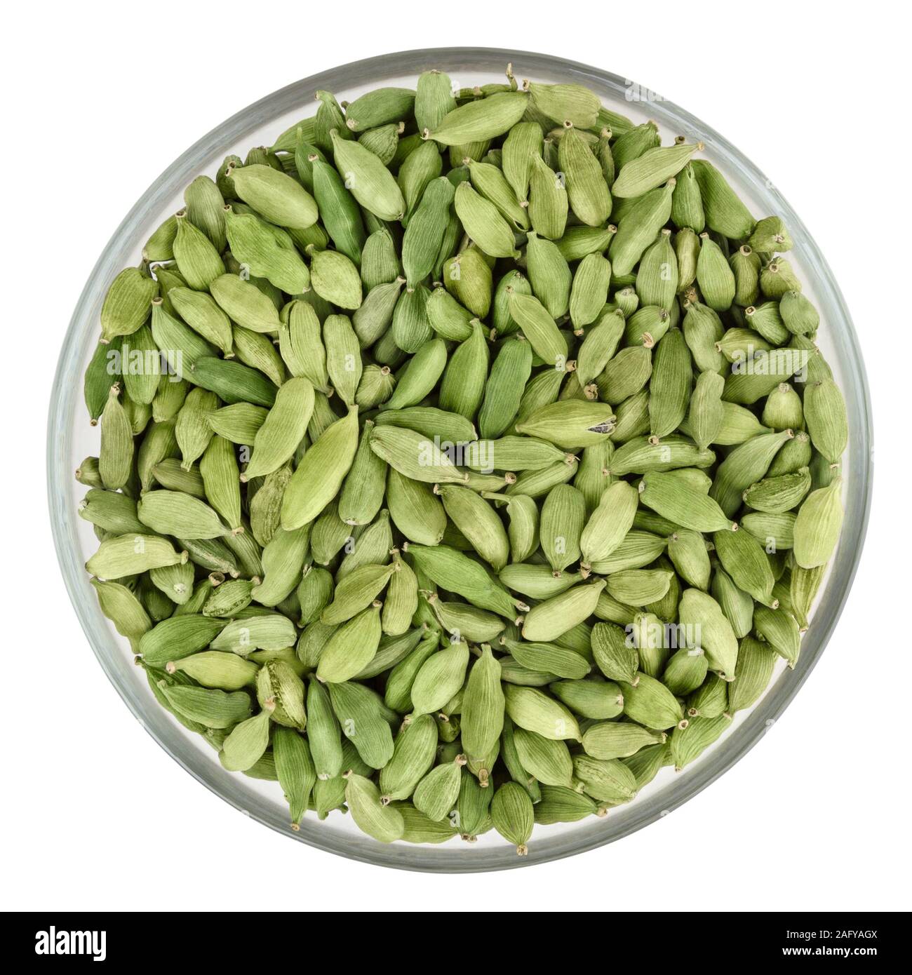 Green cardamon pods in glass bowl isolated on white background with ...