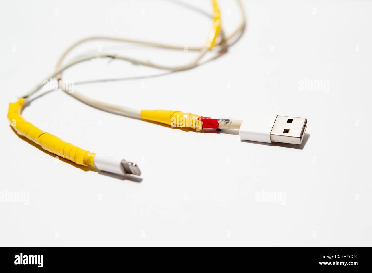 A charging cable is damaged on white background Stock Photo - Alamy
