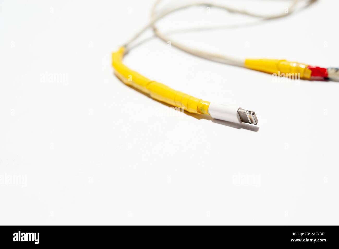 A charging cable is damaged on white background Stock Photo - Alamy