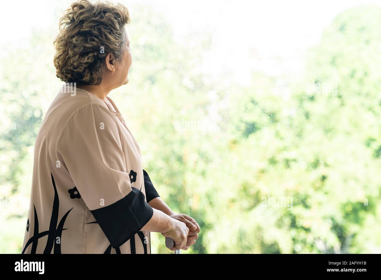 Elderly senior female using walking stick or walking cane staff ...