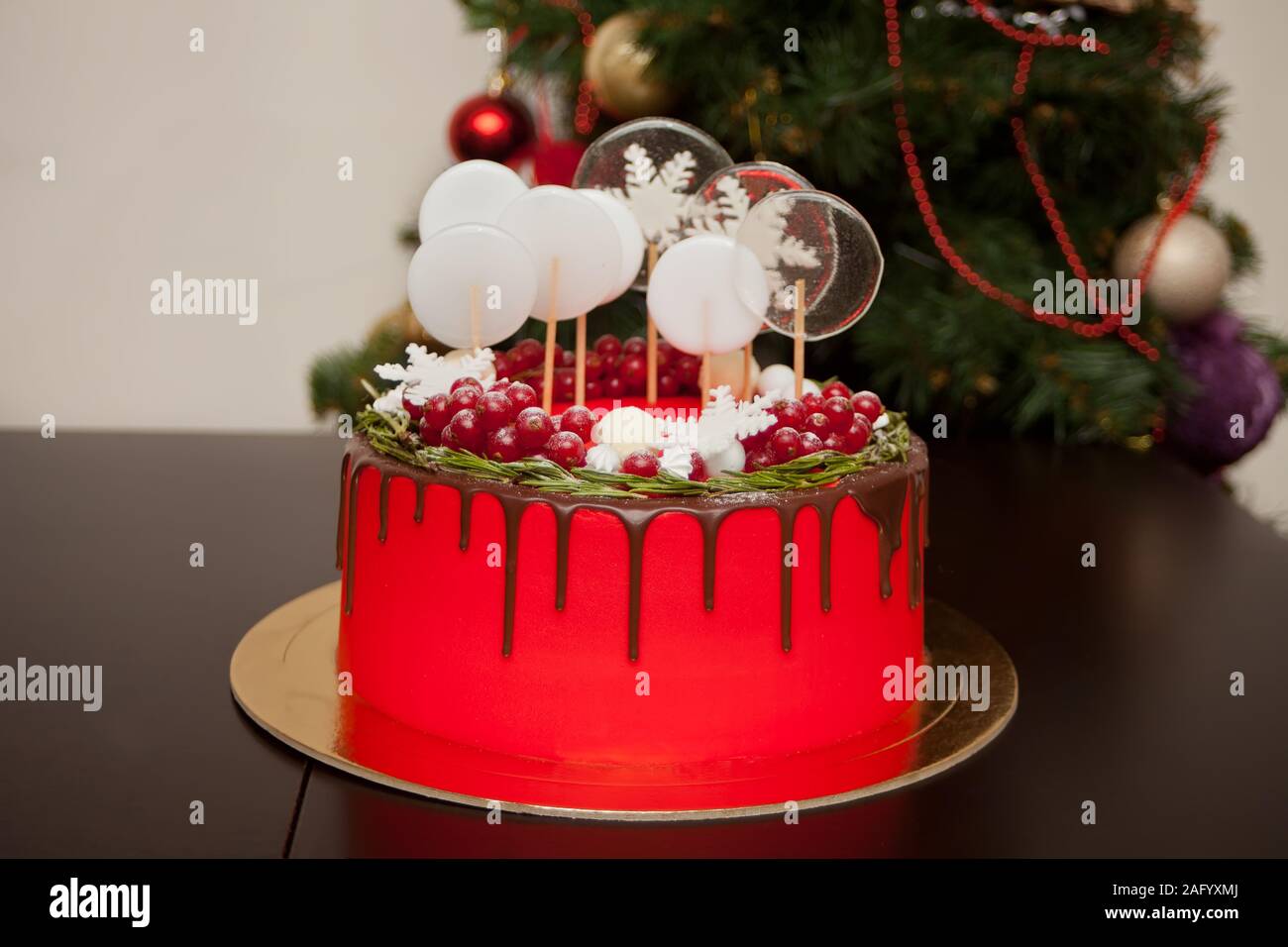 Christmas red cake with chocolate smudges, decorated red currant, candy ...