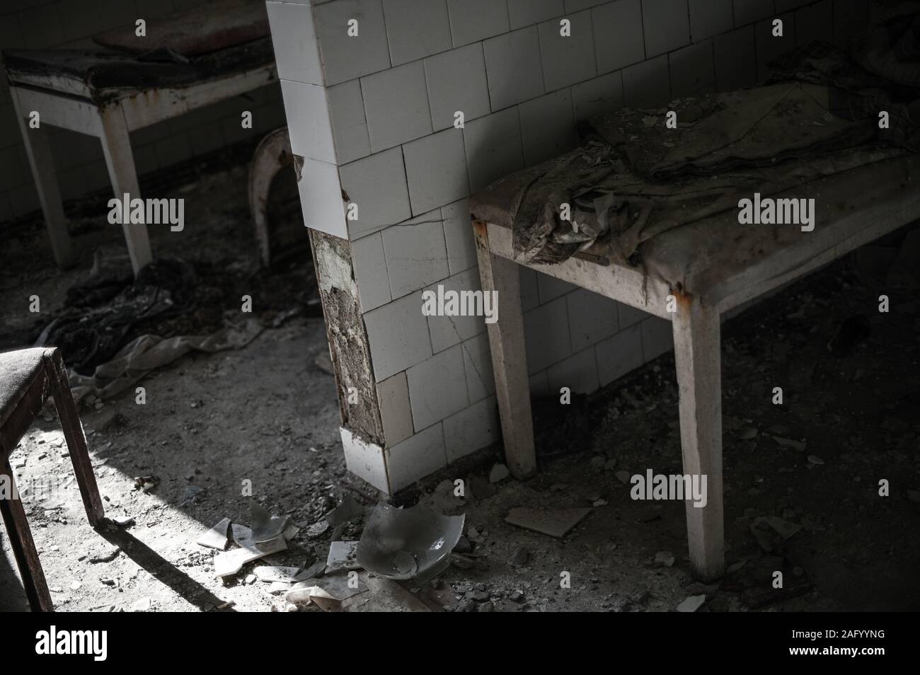 empty abandoned hospital with bed and broken glass in war zone or ...