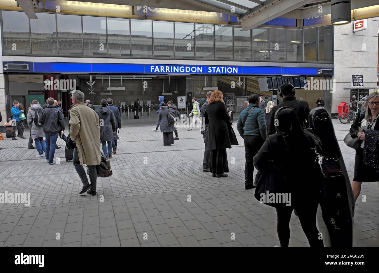 Farringdon Station sign and people commuters passengers walking outside ...