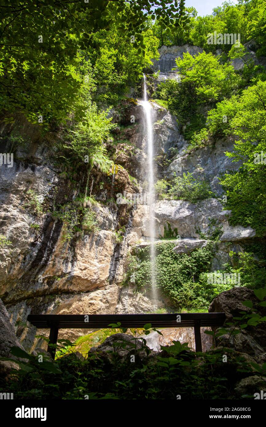 A beautiful high waterfall with a bench in front of it Stock Photo - Alamy