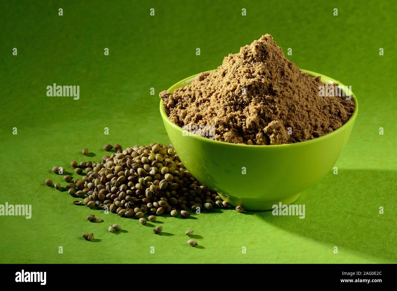 Coriander seeds and Powdered coriander in green container on green ...