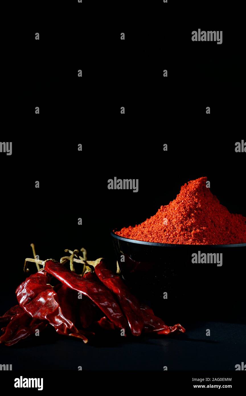 chilly powder in black bowl with red chilly, dried chillies on black ...