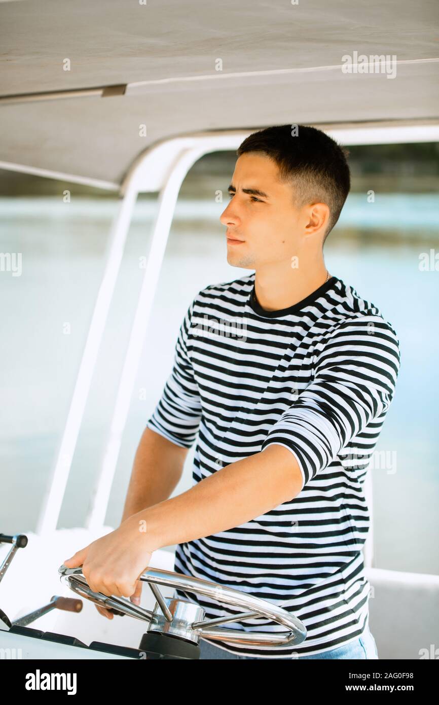 Man driving boat handsome hi-res stock photography and images - Alamy