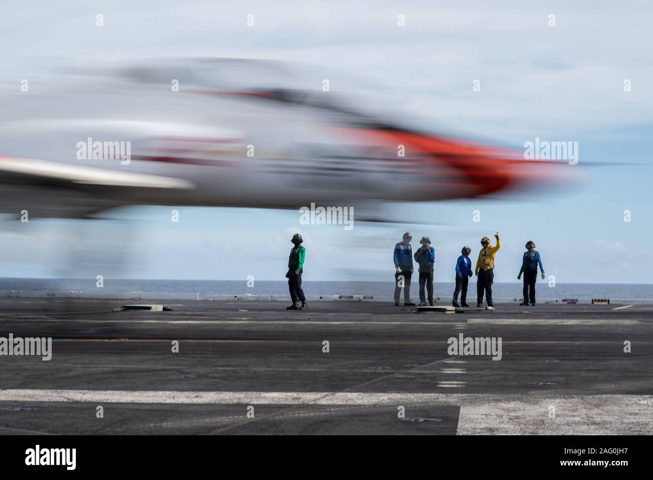 U.S. Navy sailors watch a T-45C Goshawk training jet aircraft assigned ...
