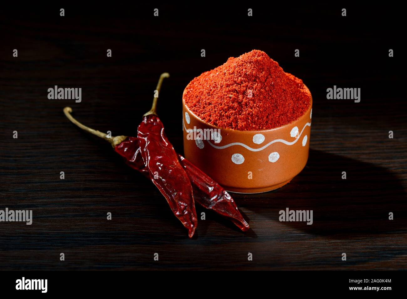 chilly powder in clay pot with red chilly, dried chillies on wooden ...