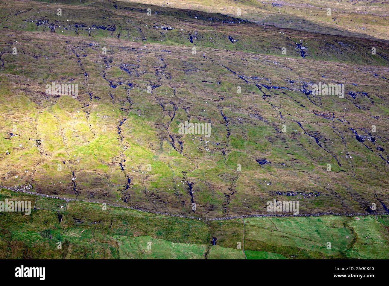 Green grass pattern of pyramid mountains lit with sun beam, Faroe ...