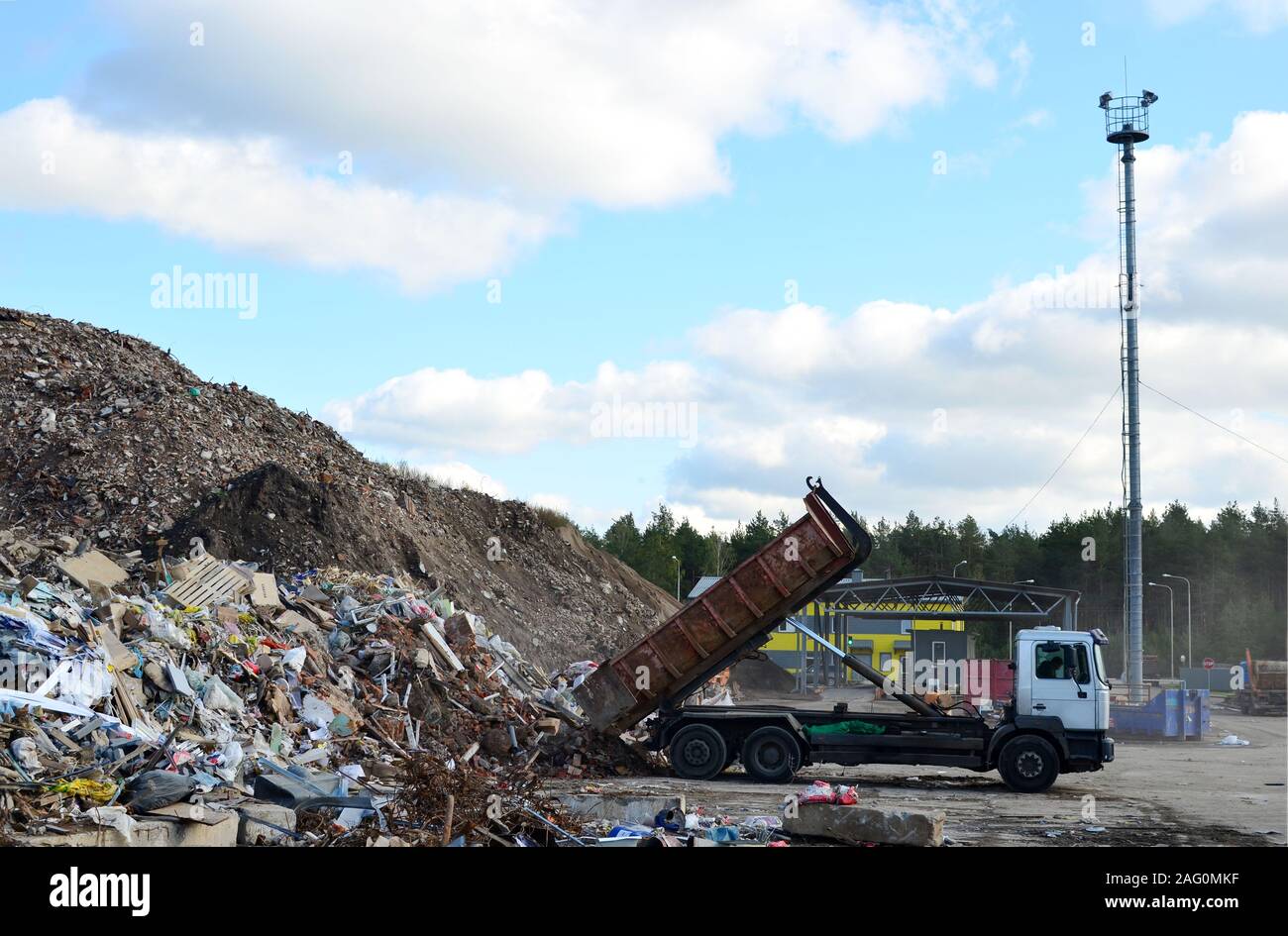 Garbage truck unloads construction waste from container at the landfill ...