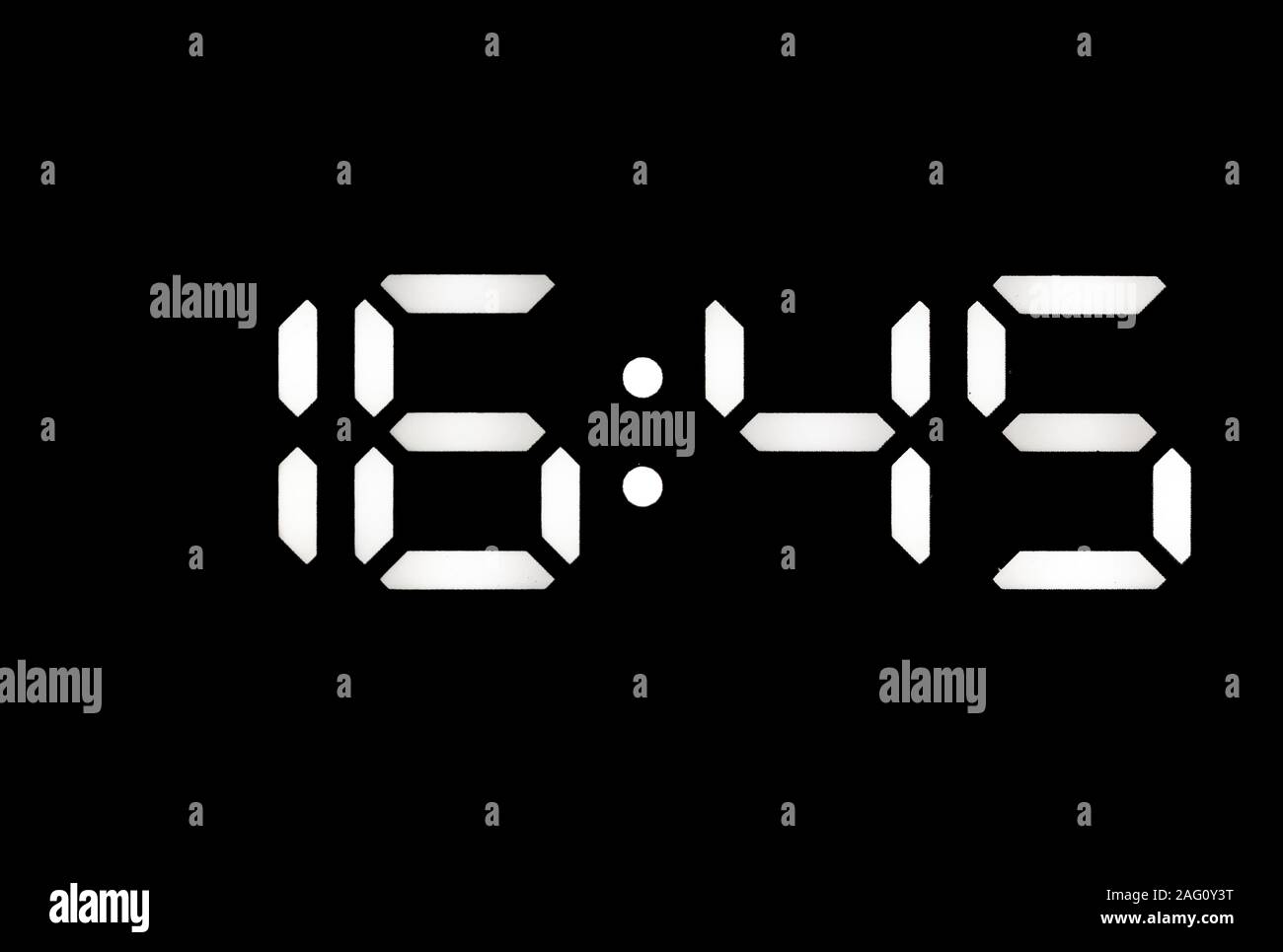 Real white led digital clock on a black background showing time 16:45 ...