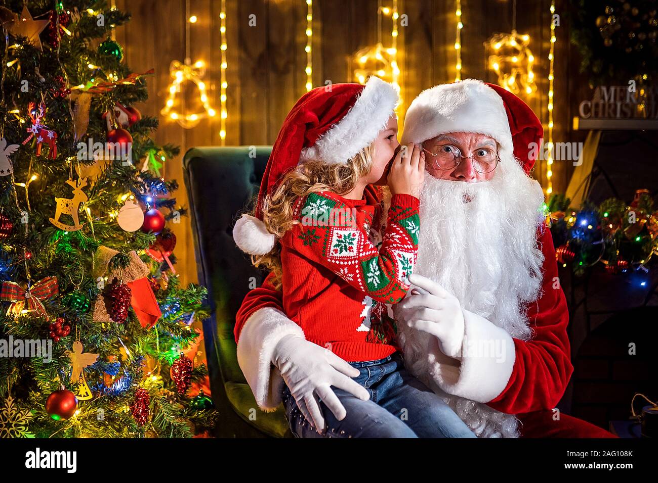 Little girl whispering in Santa's ear. Telling a secret. Revealing the ...