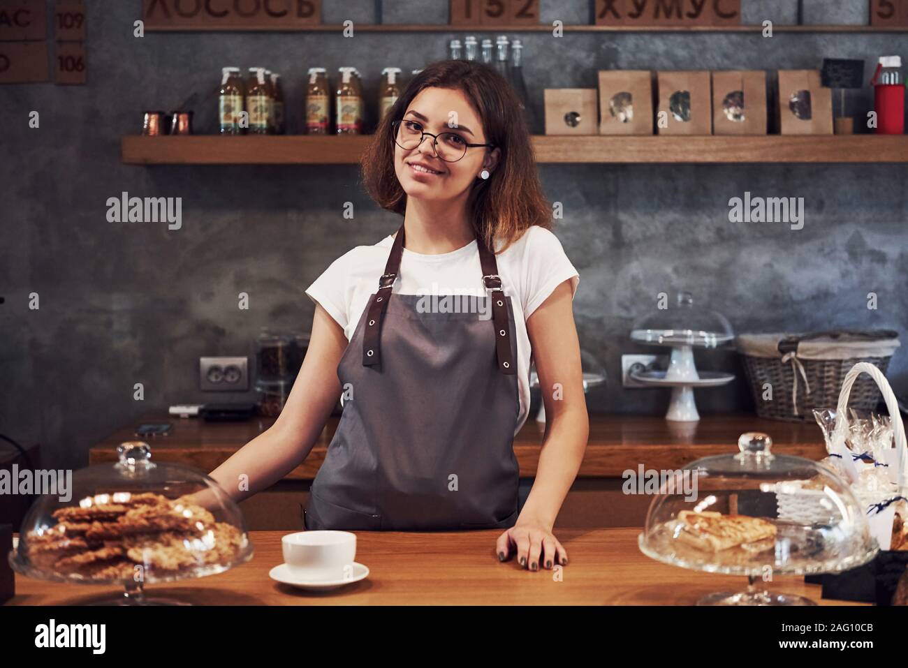 Good mood. Young female cafe worker indoors. Conception of business and ...