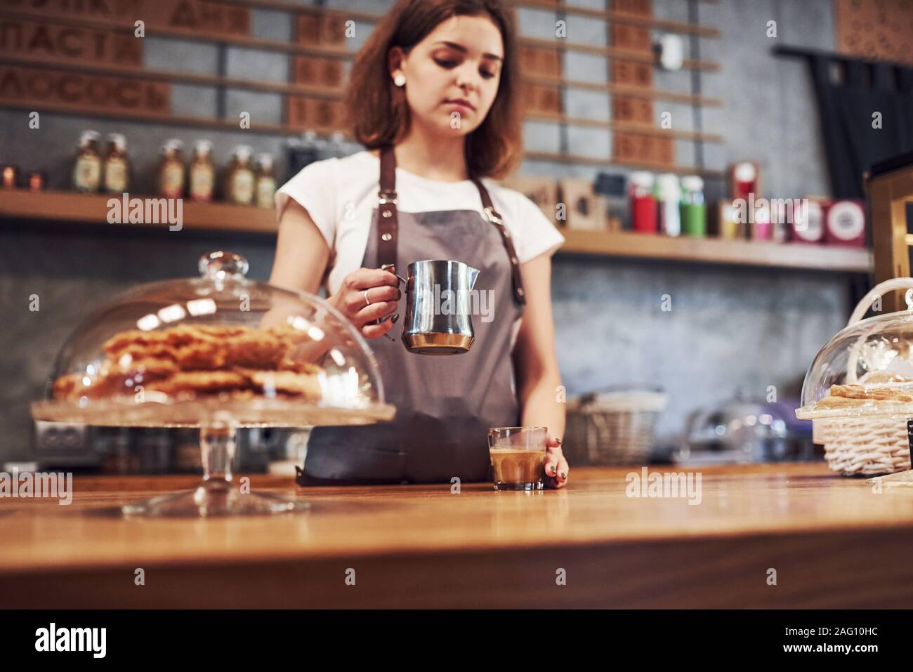 Pouring fresh coffee. Young female worker indoors. Conception of ...
