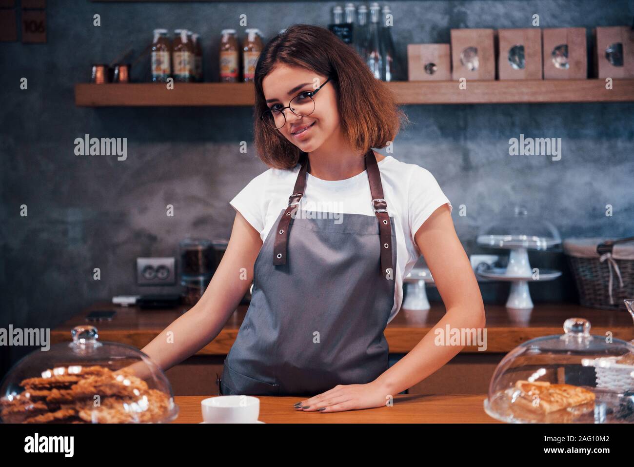 Good mood. Young female cafe worker indoors. Conception of business and ...