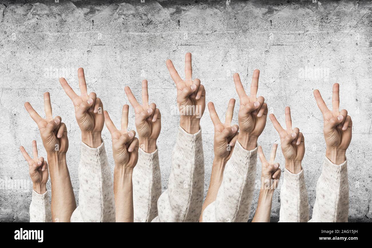Row of man hands showing victory gesture Stock Photo - Alamy