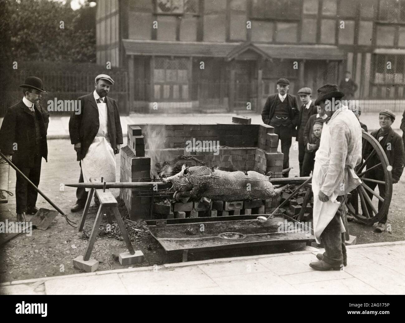 Early 20th century vintage press photograph - men roasting a pig on a ...