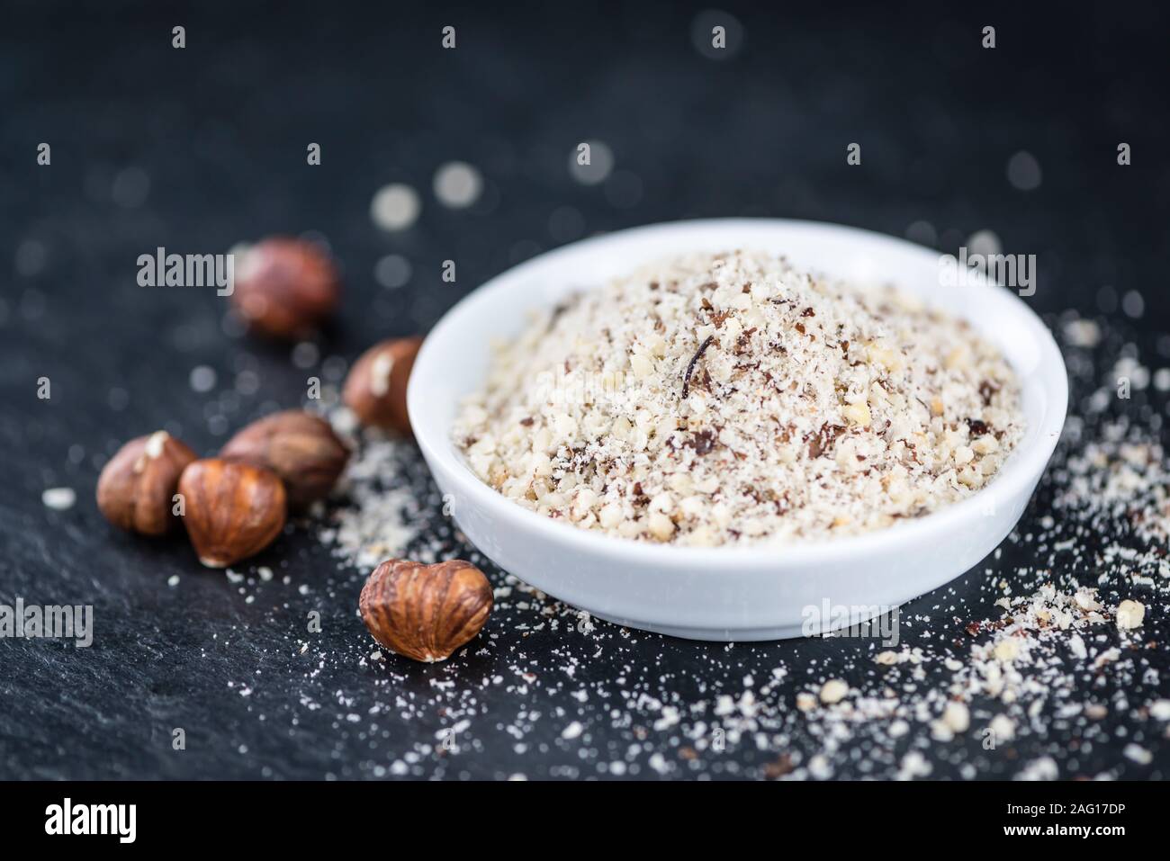 Grounded Hazelnuts (selective focus; close-up shot) on a slate slab ...