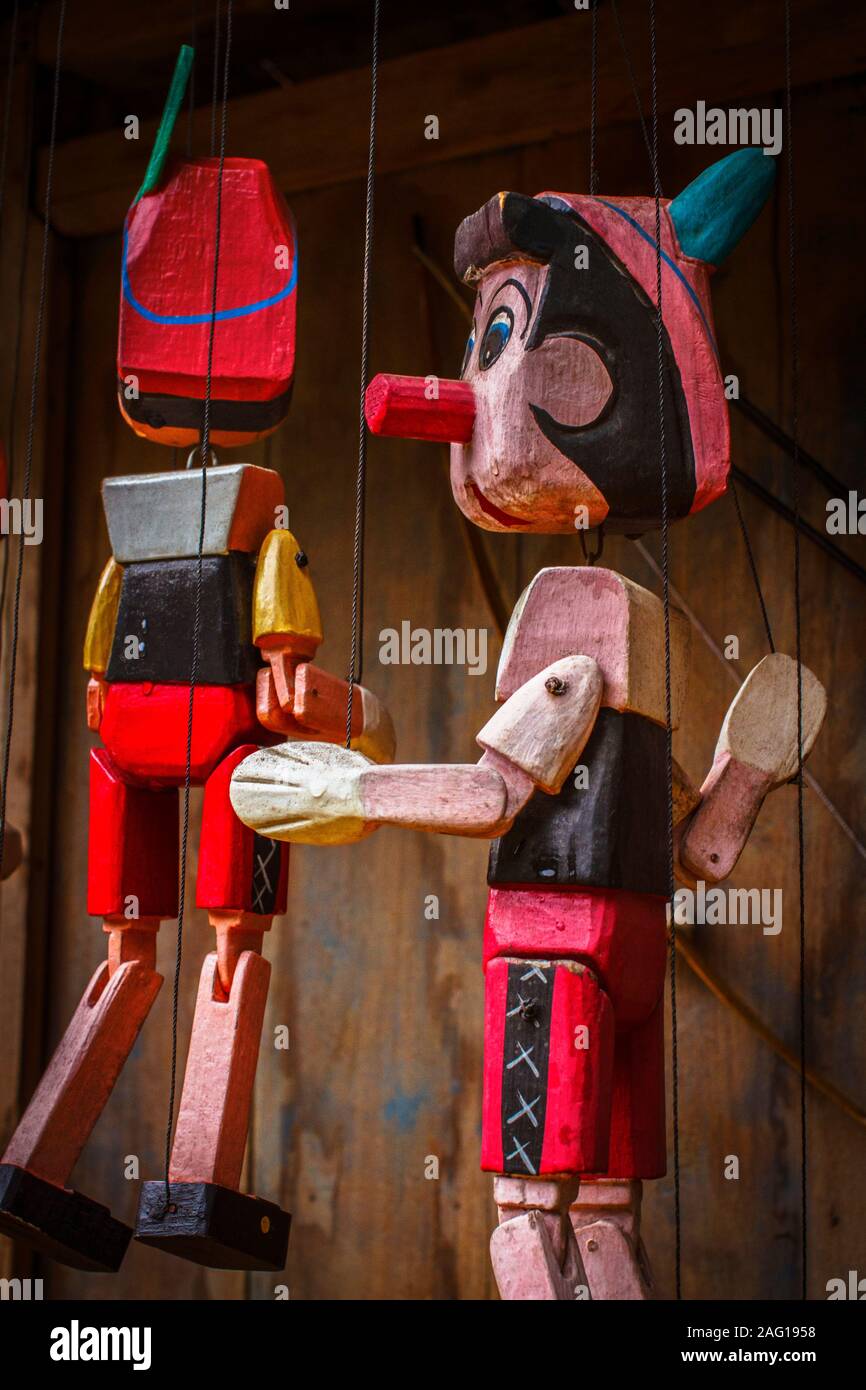 Pinocchio wooden puppet hanging outside as decoration Stock Photo - Alamy