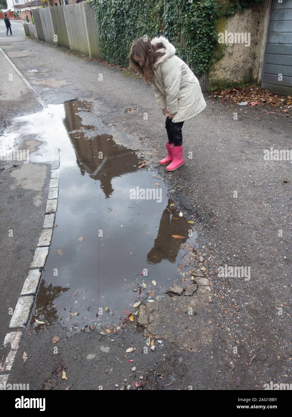 Girl Looks into Puddle Stock Photo - Alamy