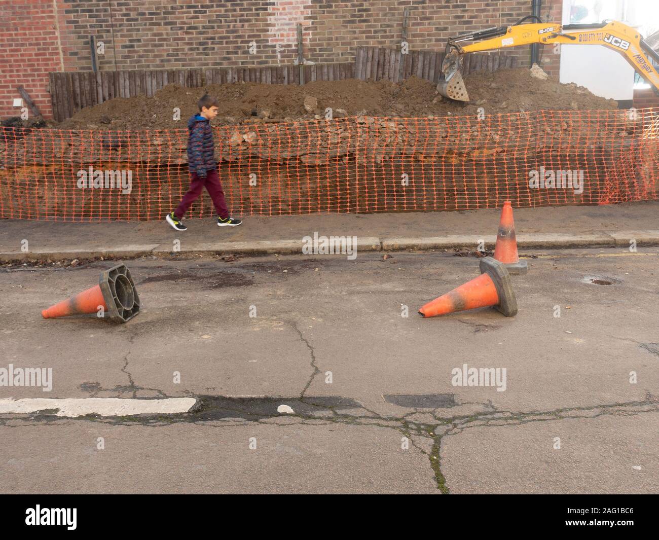 Boy walking past building site Stock Photo - Alamy