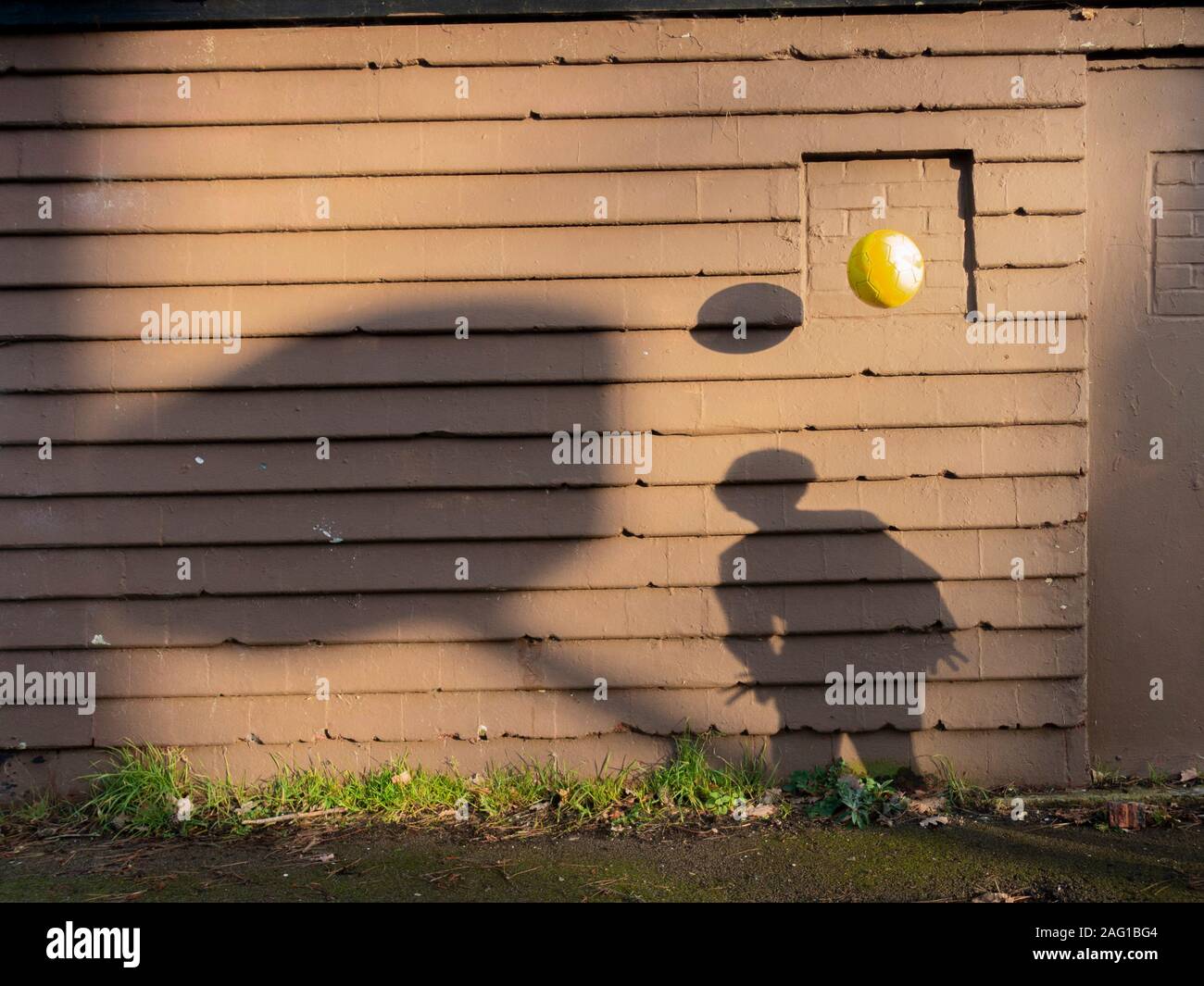 Boy playing ball and shadow Stock Photo - Alamy