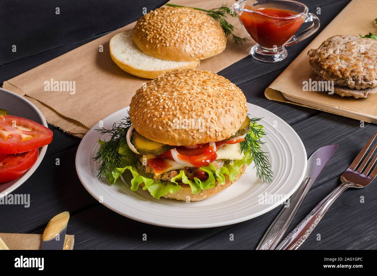 Ready-made hamburger with ingredients on a plate on a black wooden ...