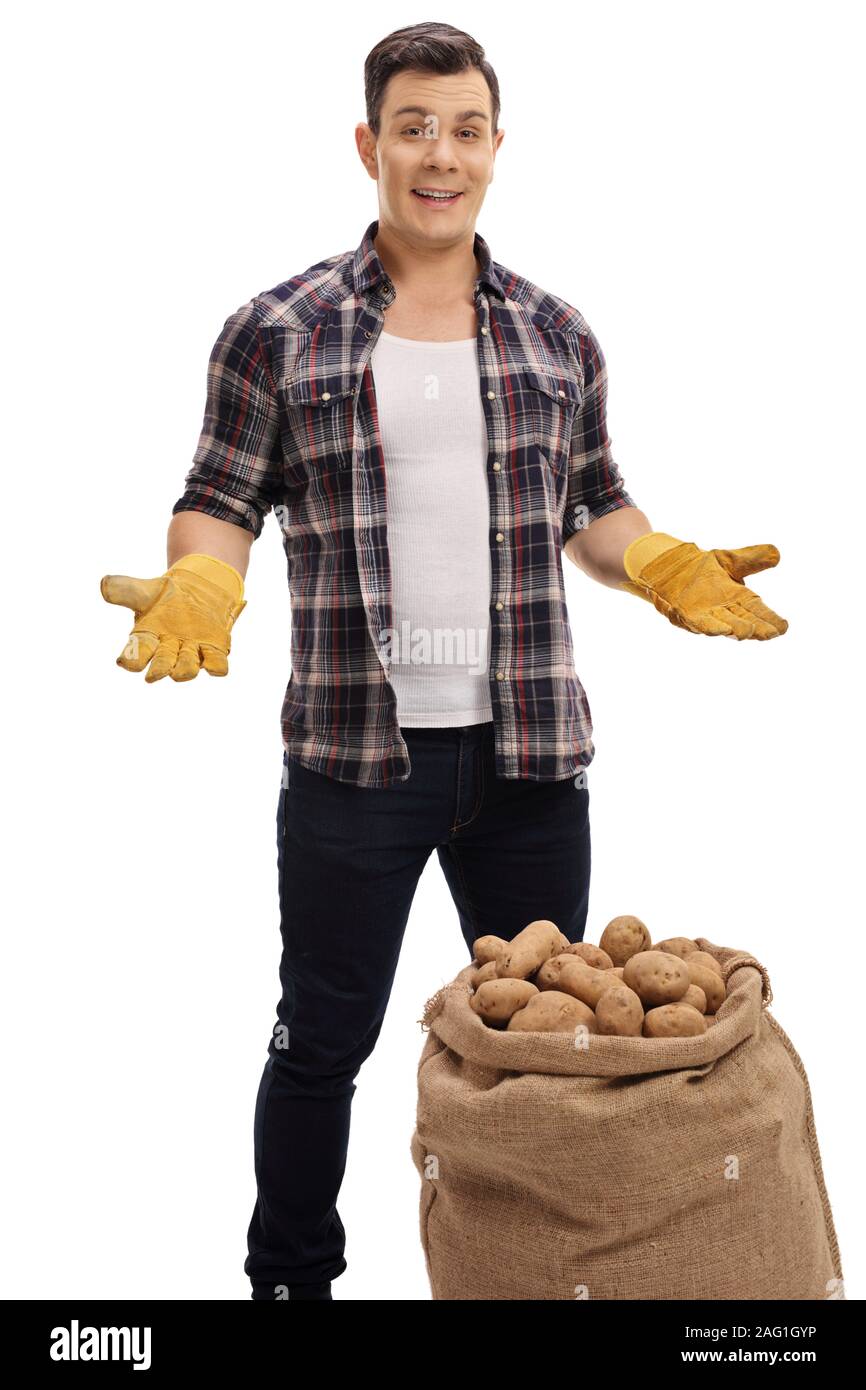 Young male farmer with a sack of potatoes isolated on white background ...