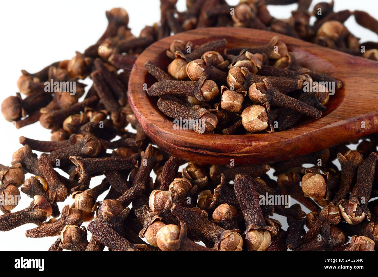 Cloves (spice) and wooden spoon close-up food background. Isolated on ...